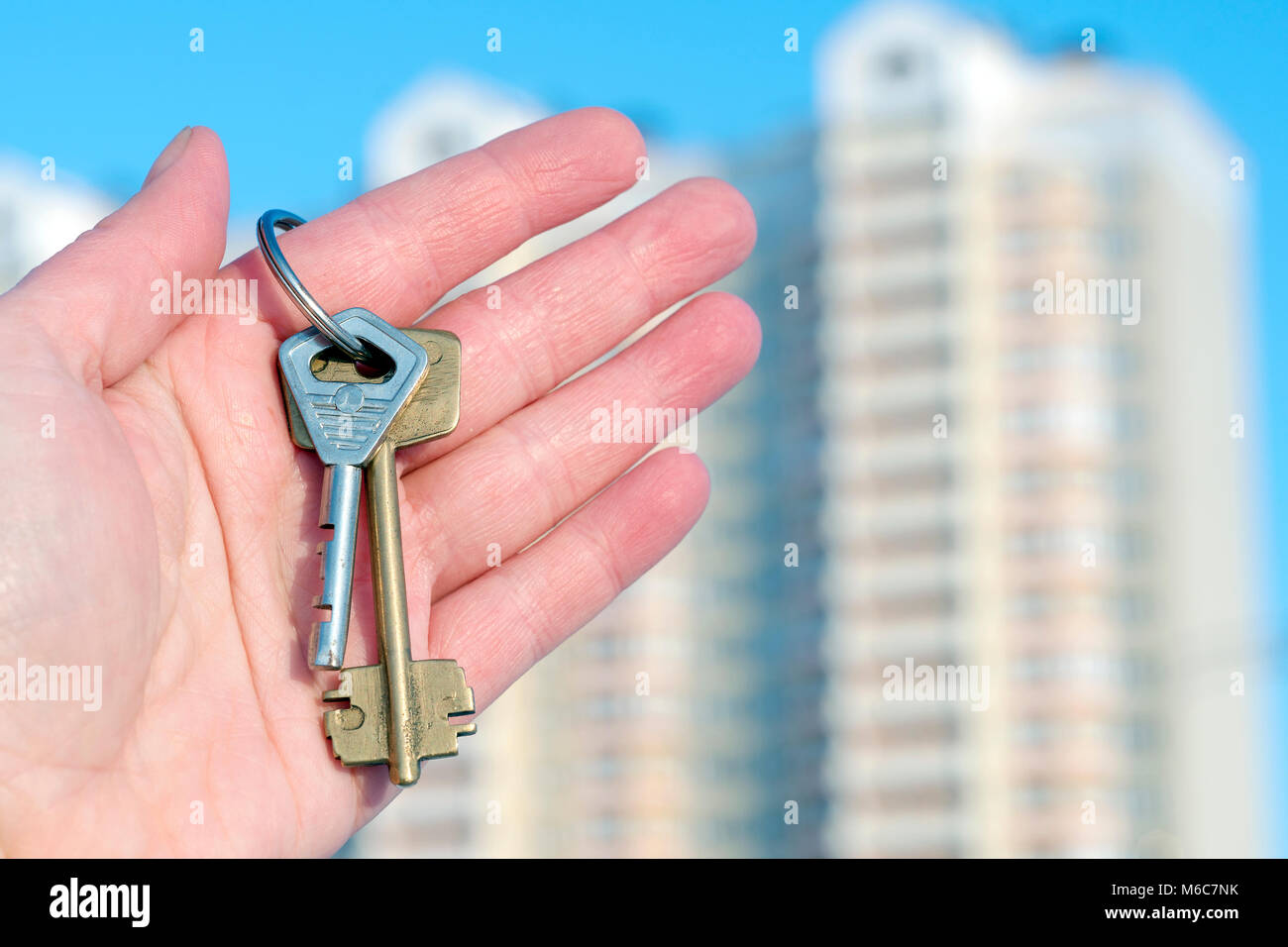 The hand of a white man holds the keys on the background of an ...
