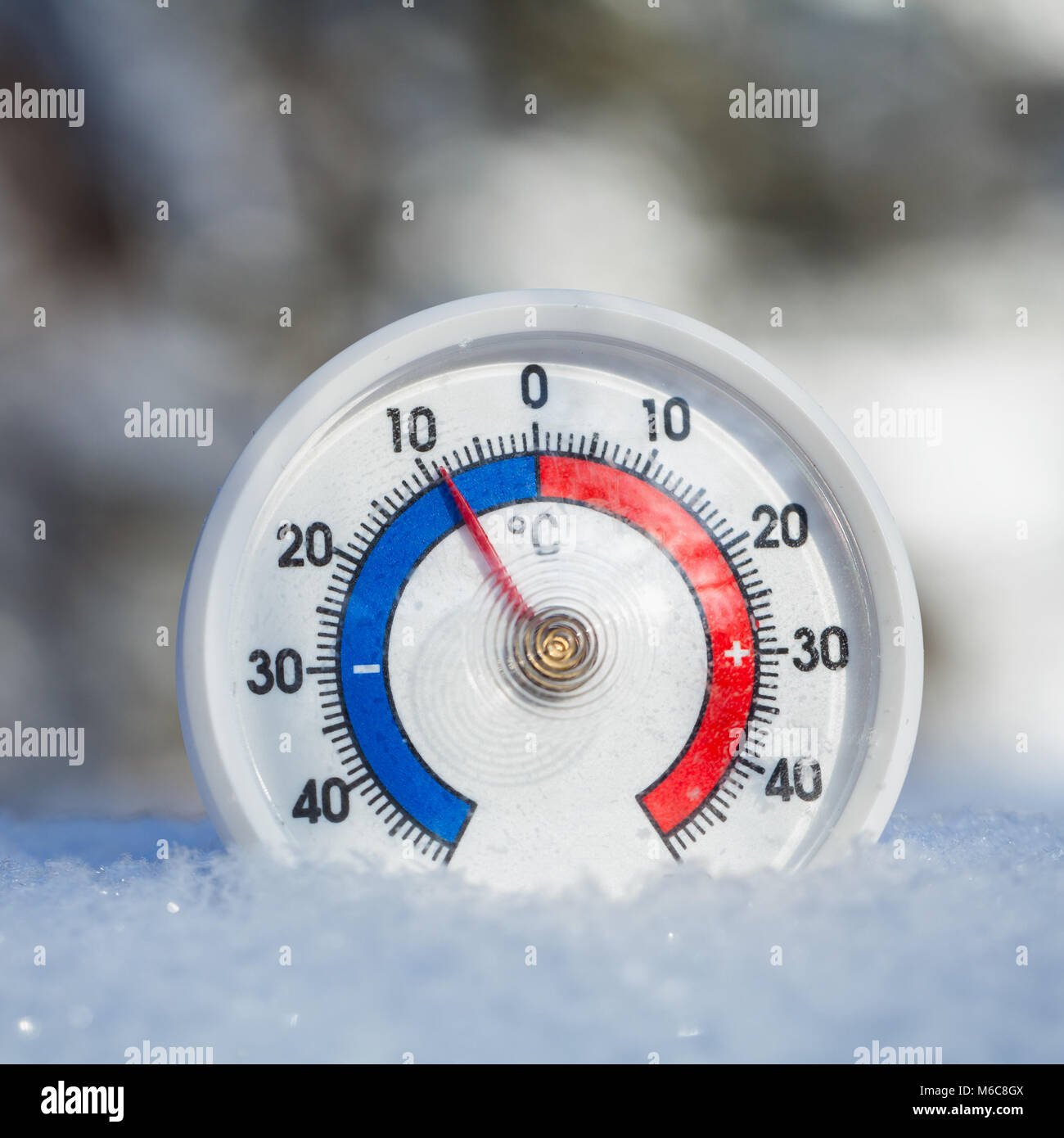 Thermometer with celsius scale placed in a fresh snow showing sub-zero ...