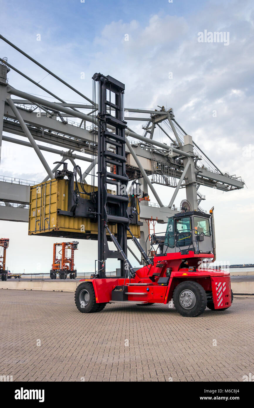 Mobile cargo container handler in action at a shipping container ...