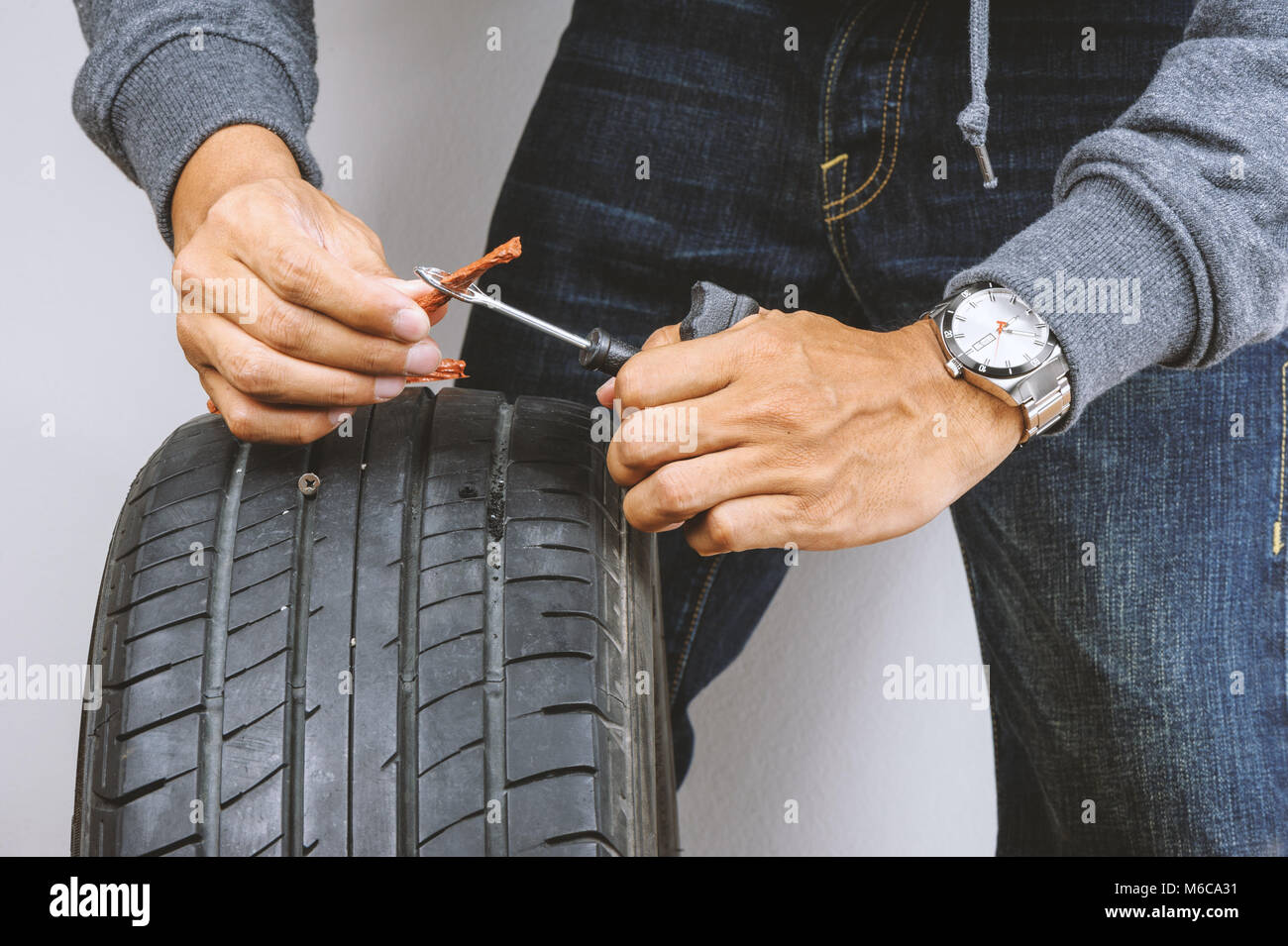The man repairing flat car tire with repair kit, Tire plug repair kit ...