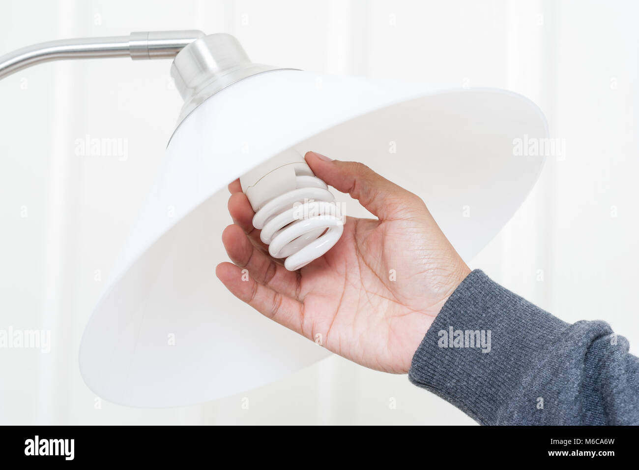 closeup hand changing an electric light bulb Stock Photo - Alamy