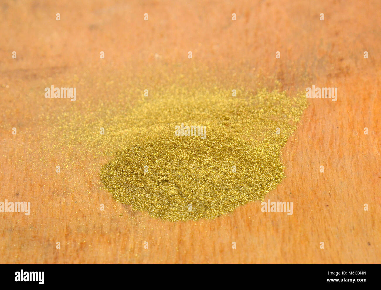image of a gold glitter powder on wood background Stock Photo - Alamy