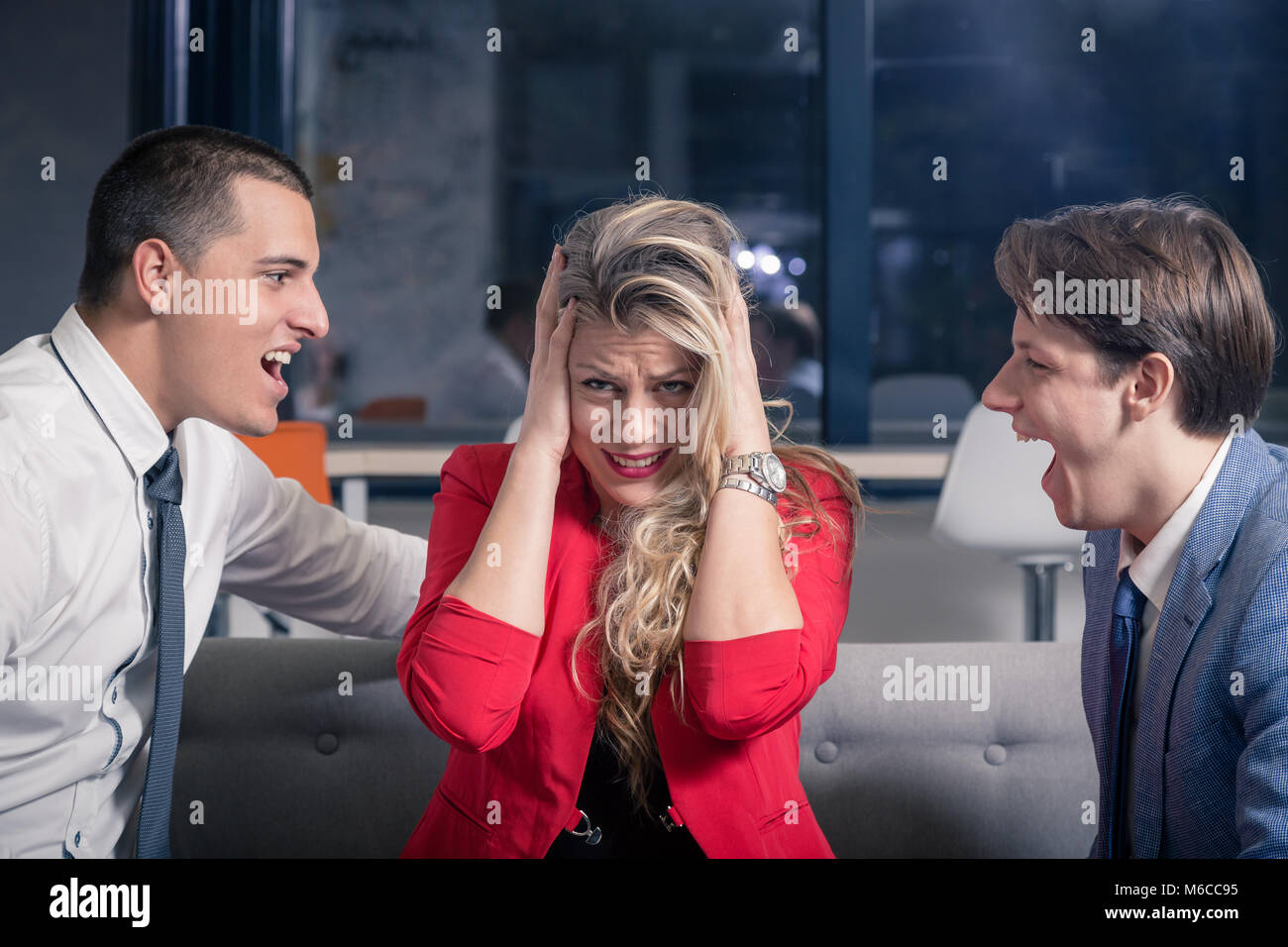 Annoyed businesswoman covering her ears with hands and two man yelling ...
