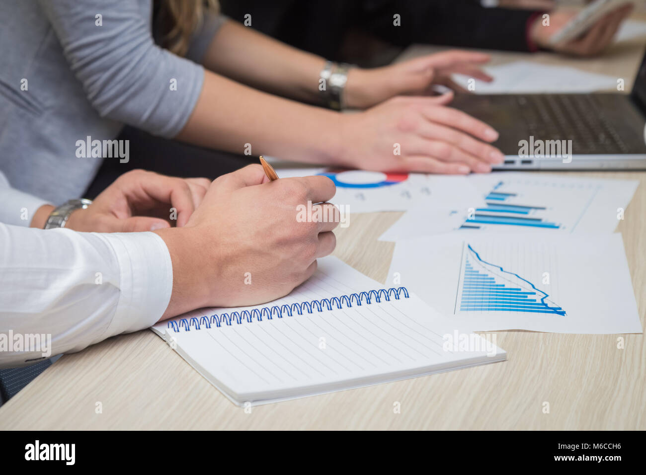 Close up of man hands taking notes and business documents and charts on ...