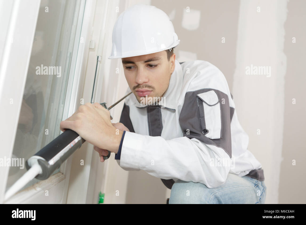 applying caulking on the gaps Stock Photo - Alamy