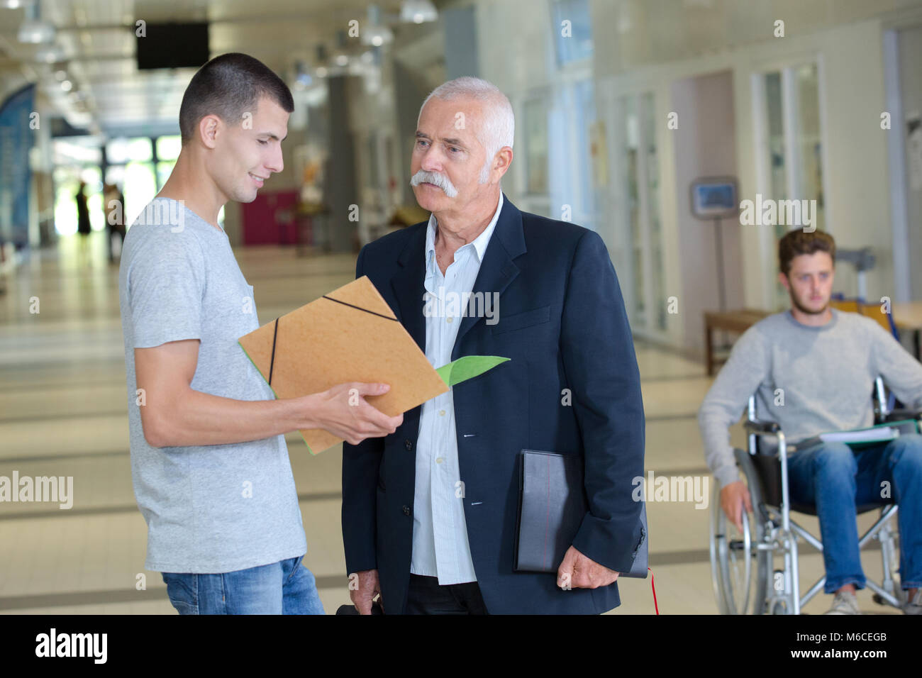 student and professor talking in the hallway Stock Photo - Alamy