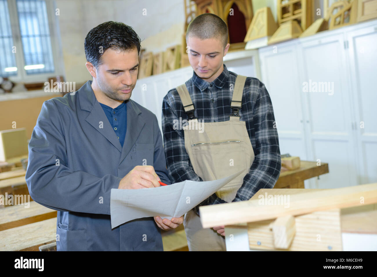 boss and apprentice working in a carpenters workshop Stock Photo - Alamy