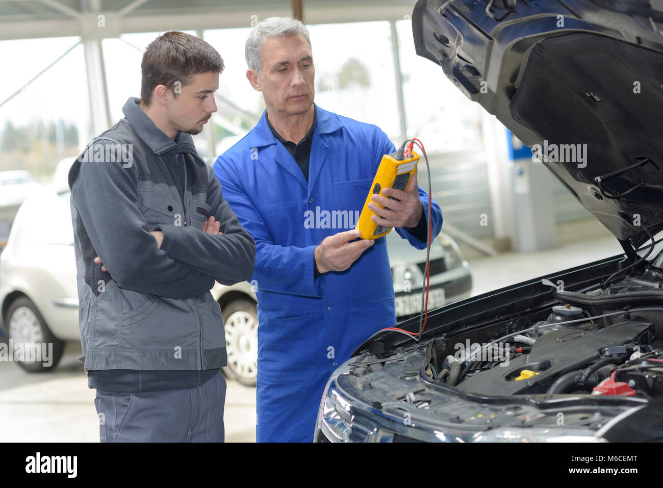student with instructor repairing a car during apprenticeship Stock ...