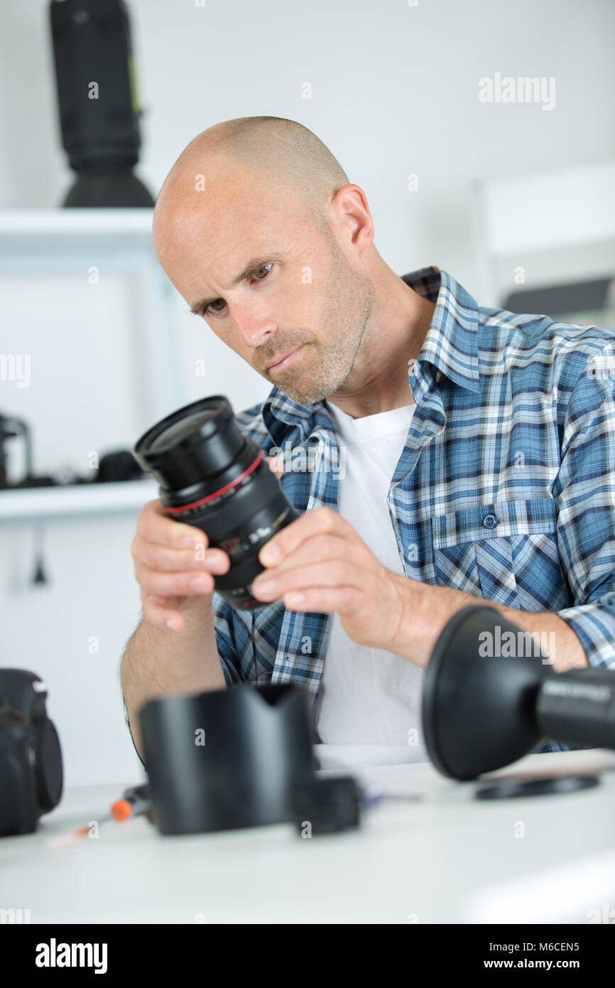 focused man fixing camera at his workplace Stock Photo - Alamy
