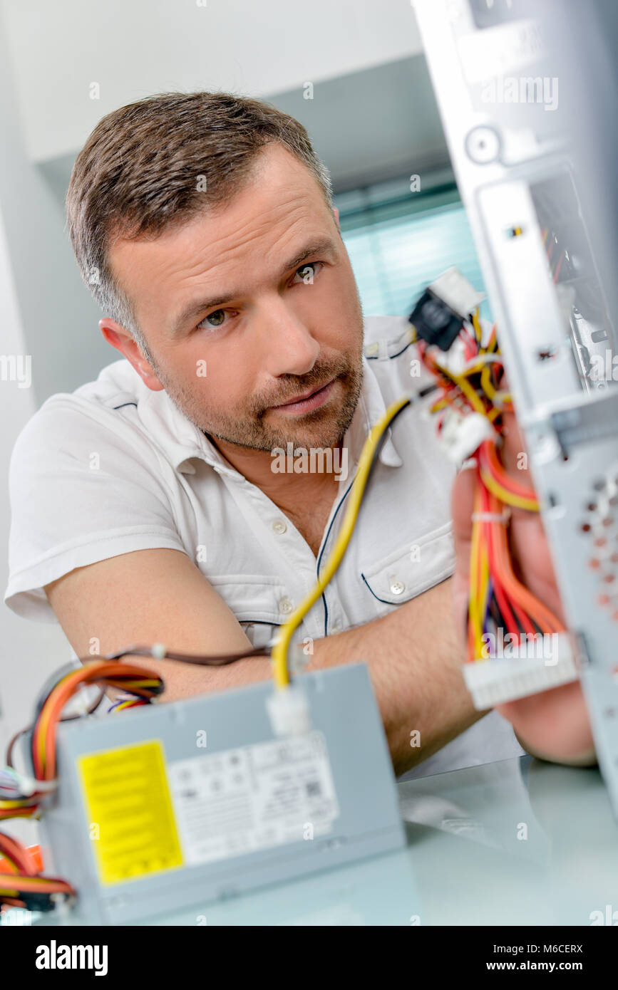 Fixing his computer Stock Photo - Alamy