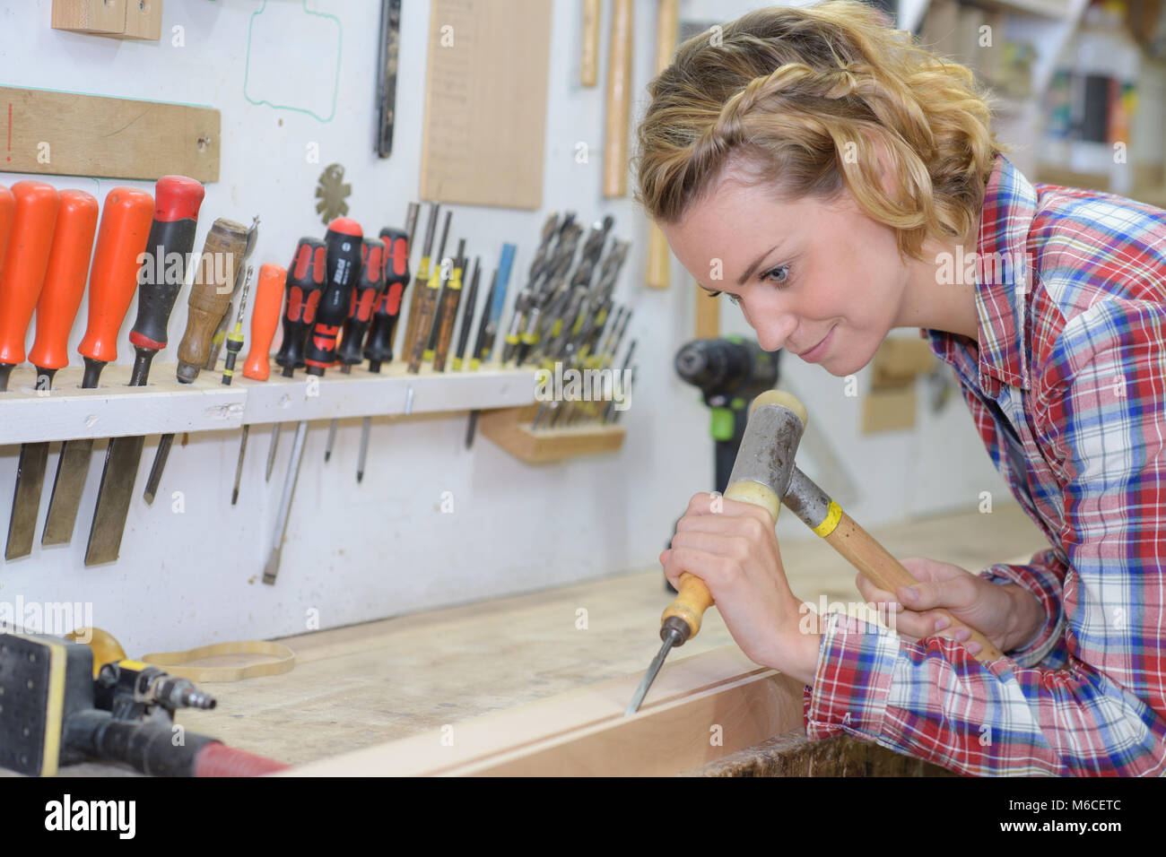 craftswoman working with chisel and hammer in her workshop Stock Photo ...