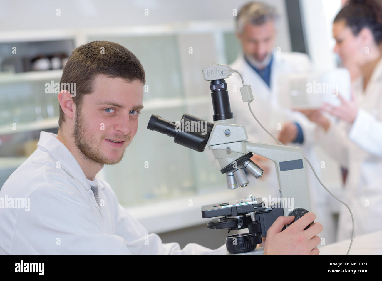 young male scientist with a microscope checking his sample Stock Photo ...