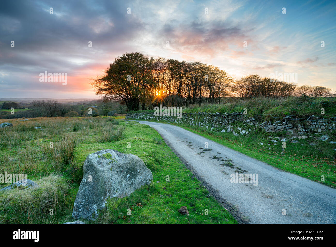 Sunset over a country lane winding through Bodmin Moor in the Cornish ...