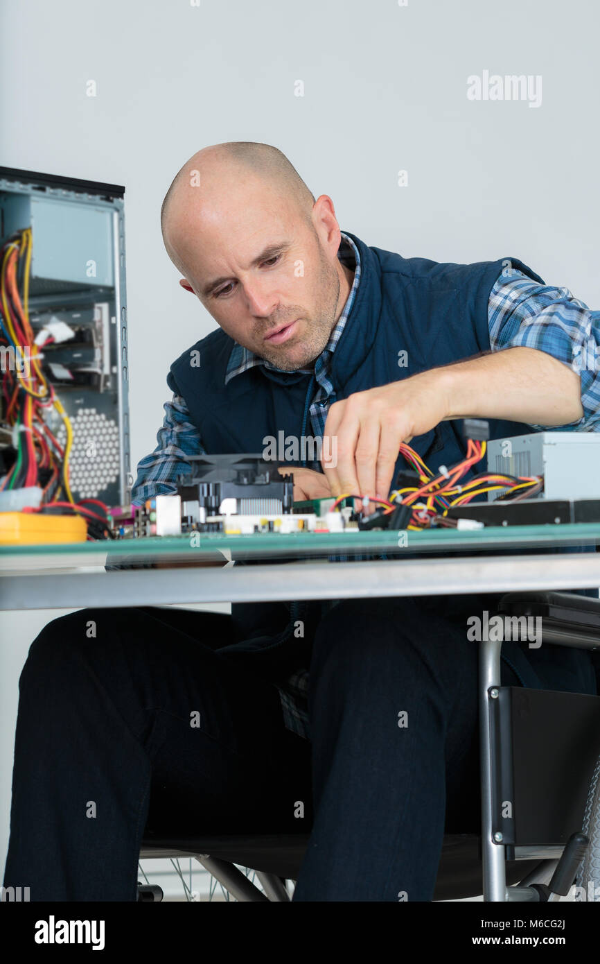Disabled man repairing computer Stock Photo - Alamy