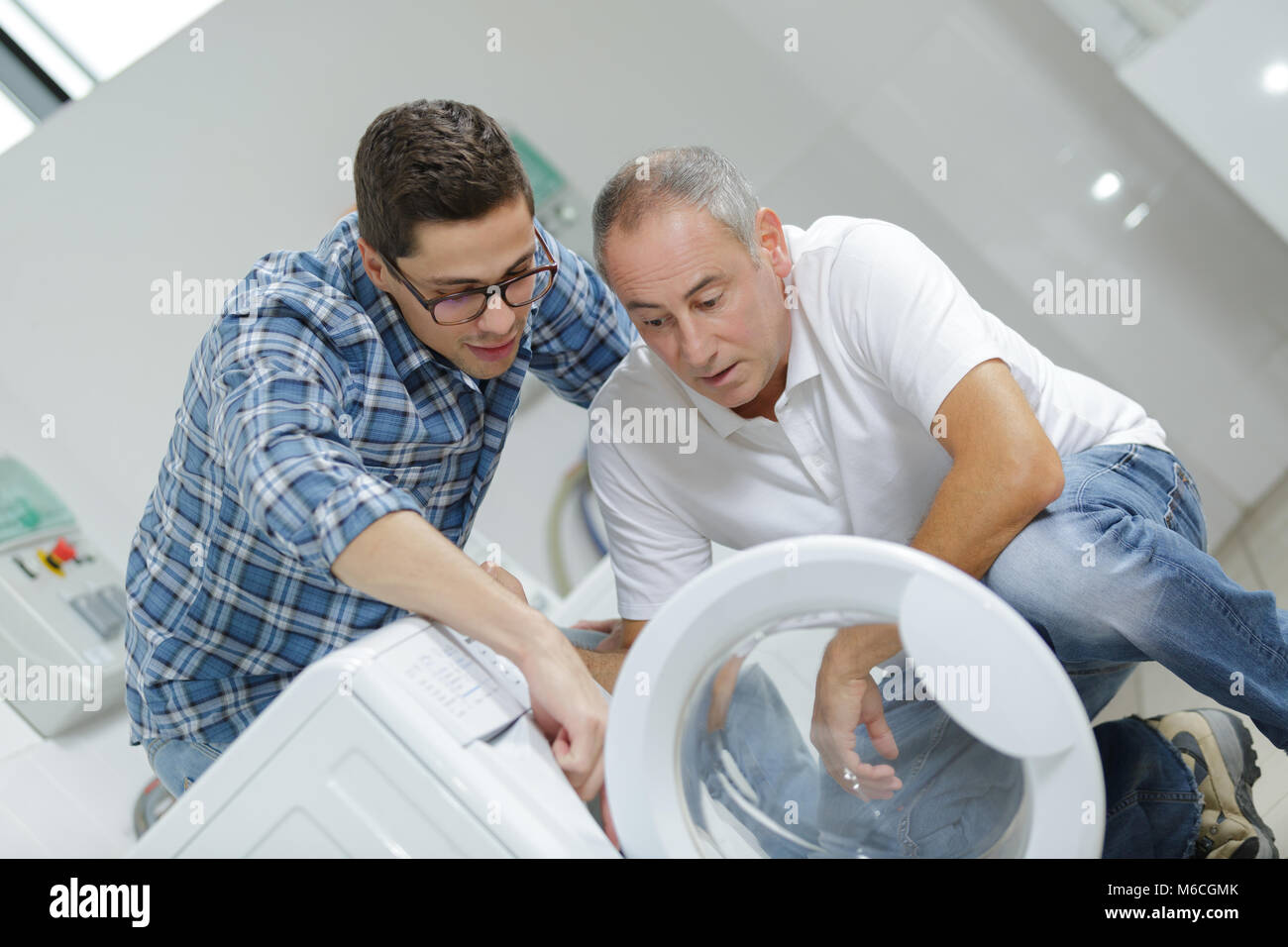 trainee and mentor fixing a washing machine Stock Photo - Alamy