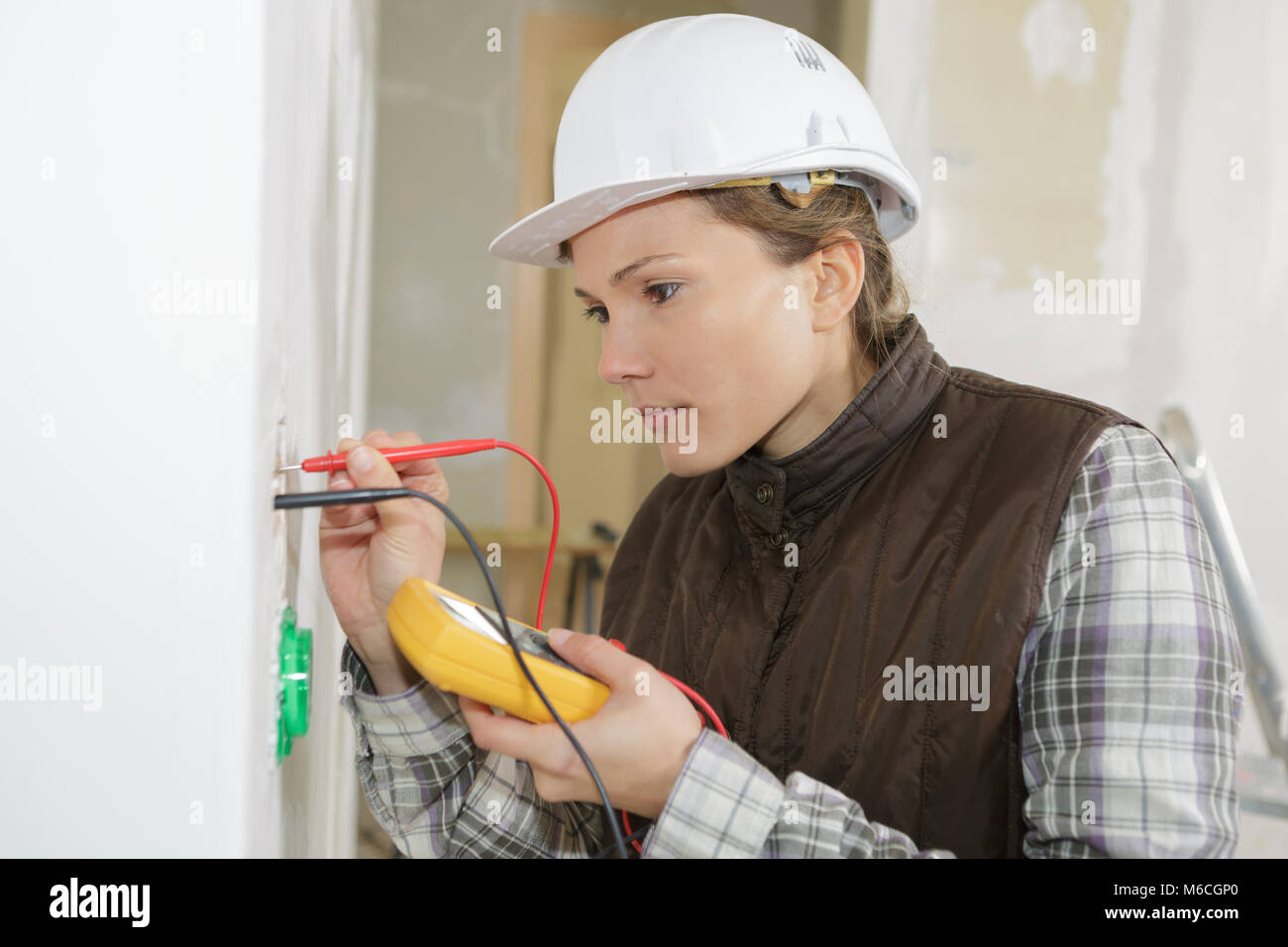 female electrician turning to smile Stock Photo - Alamy