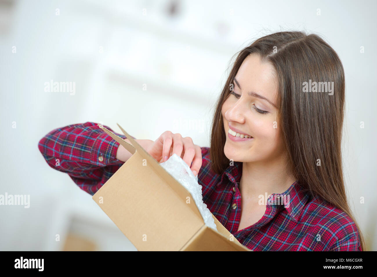 cute girl opening a package Stock Photo - Alamy