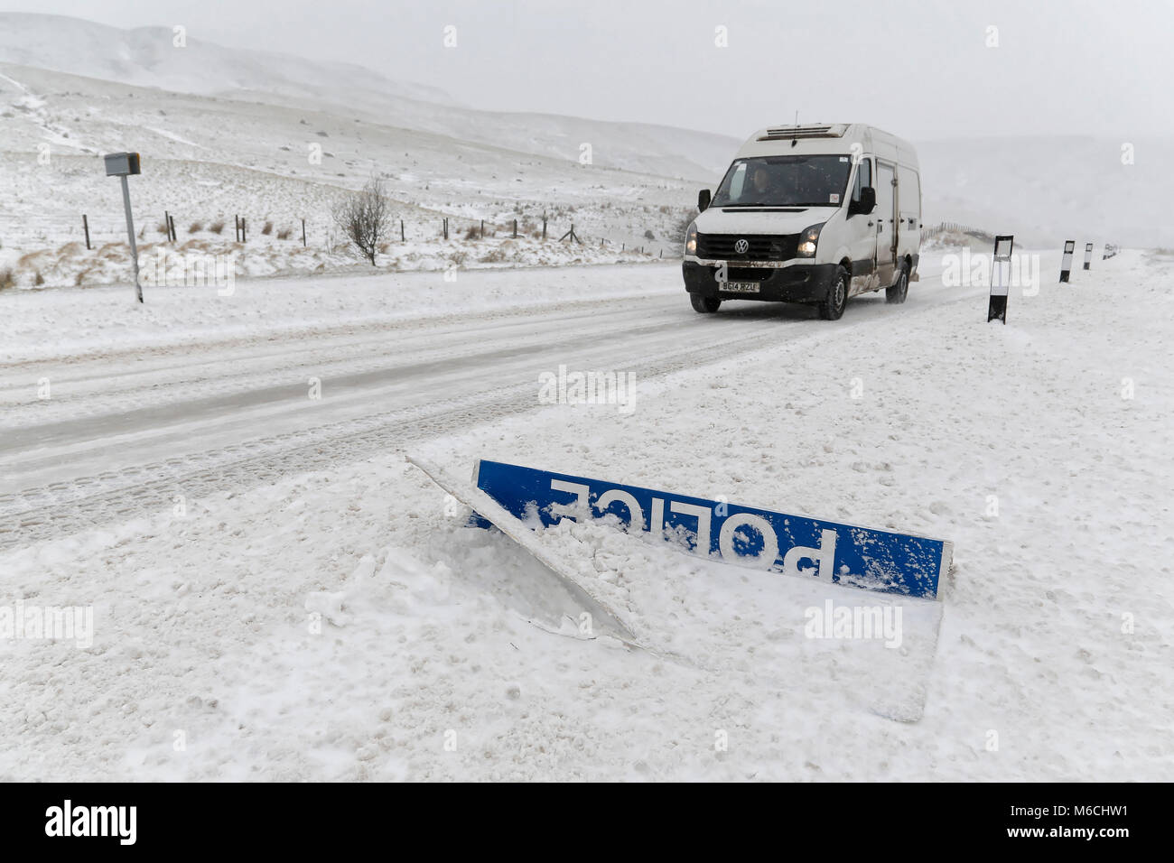 WEATHER PICTURE WALES Pictured: A van drives past a "Police Slow" sign ...