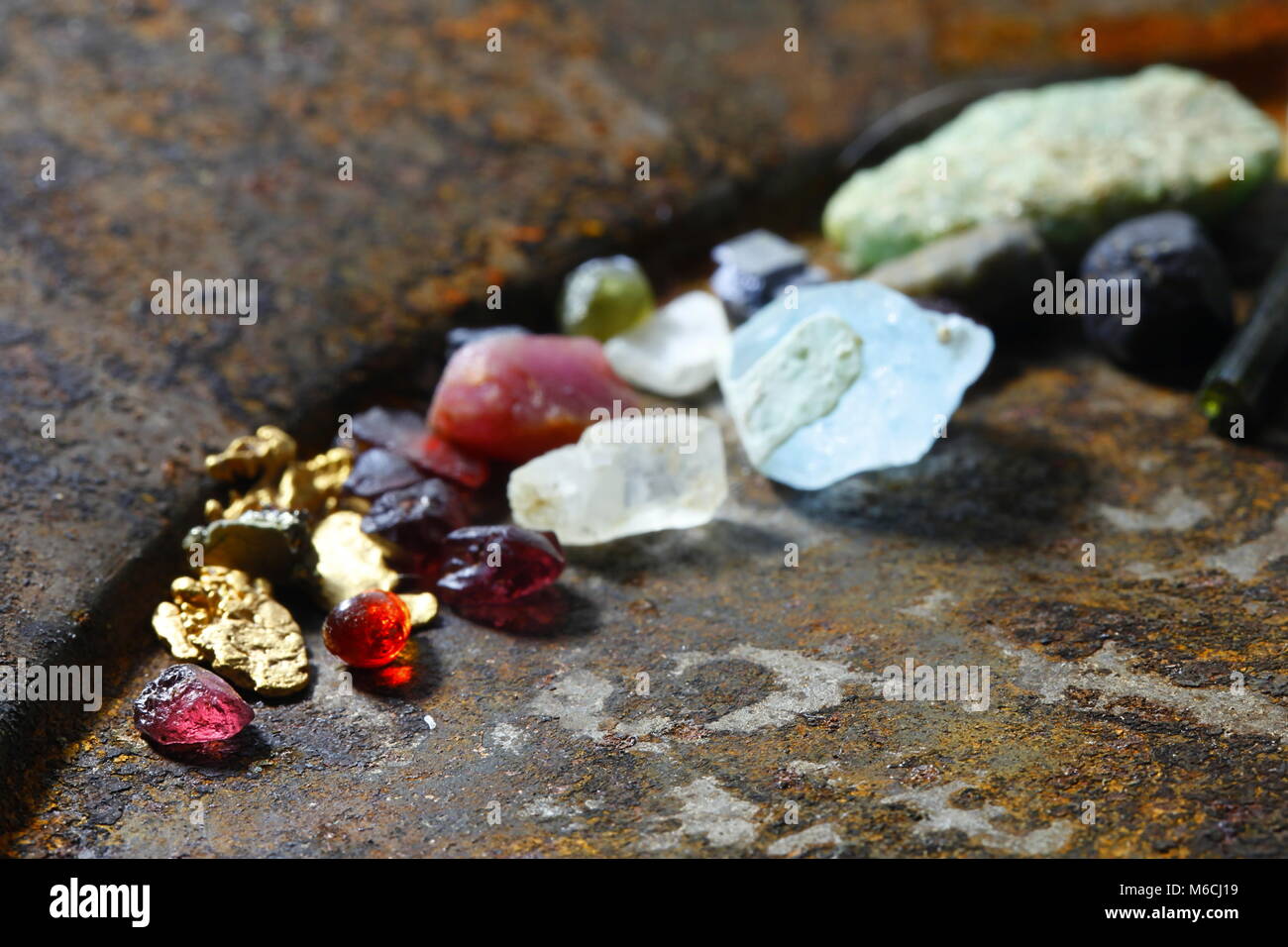 Deep red almandine garnets, nuggets of gold, moonstone, a pink ruby and ...