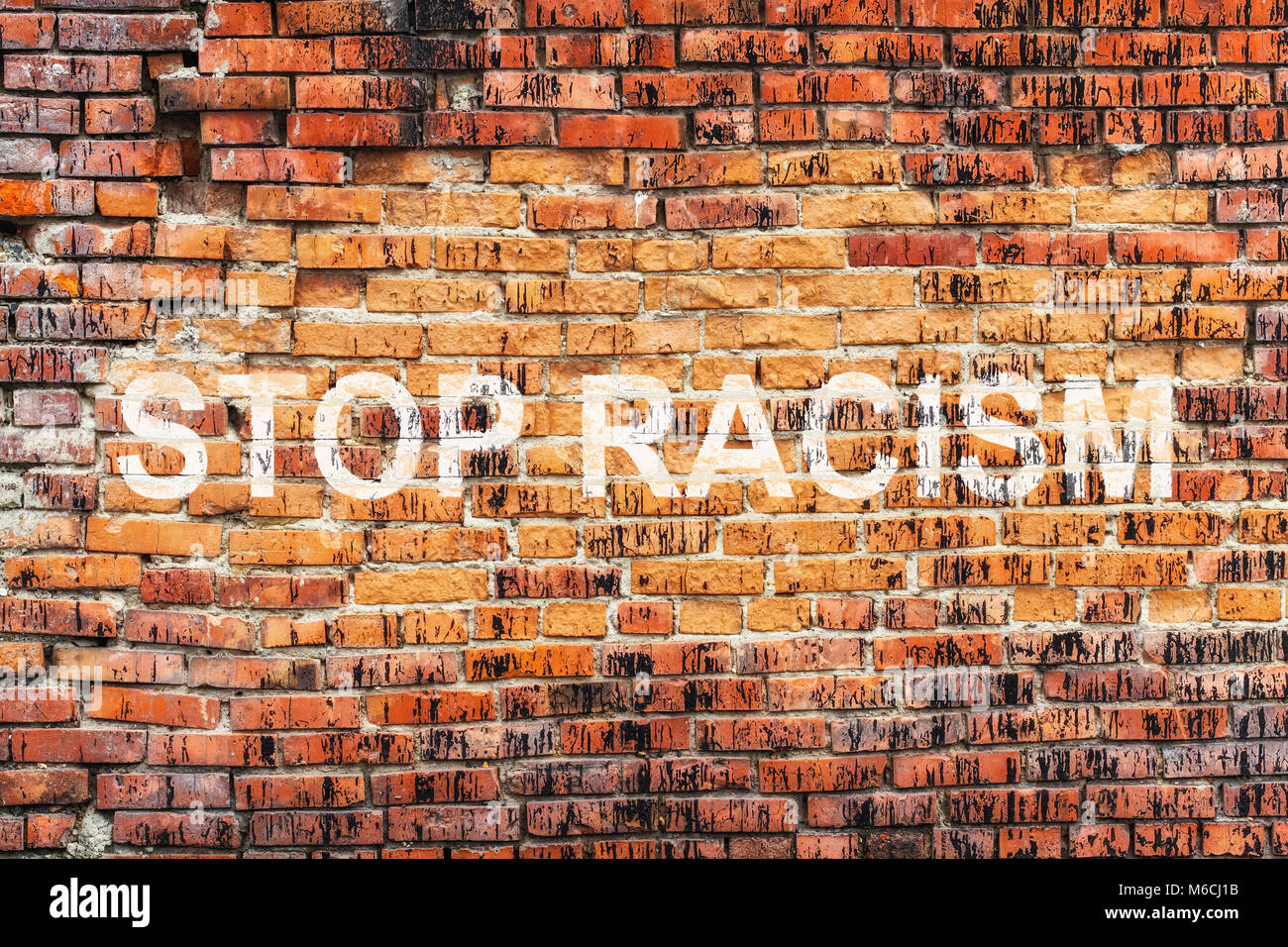 Text STOP RACISM on weathered stained old orange brick wall texture ...