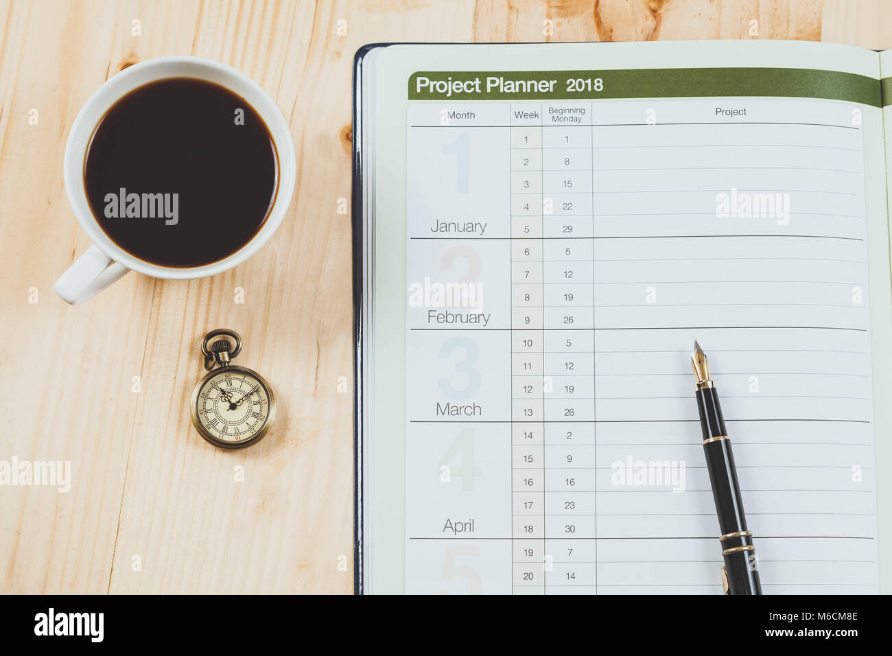 personal project planner with fountain pen and hot coffee on wood table ...
