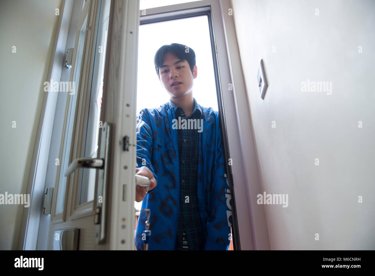 an international overseas student lets himself into his student let ...