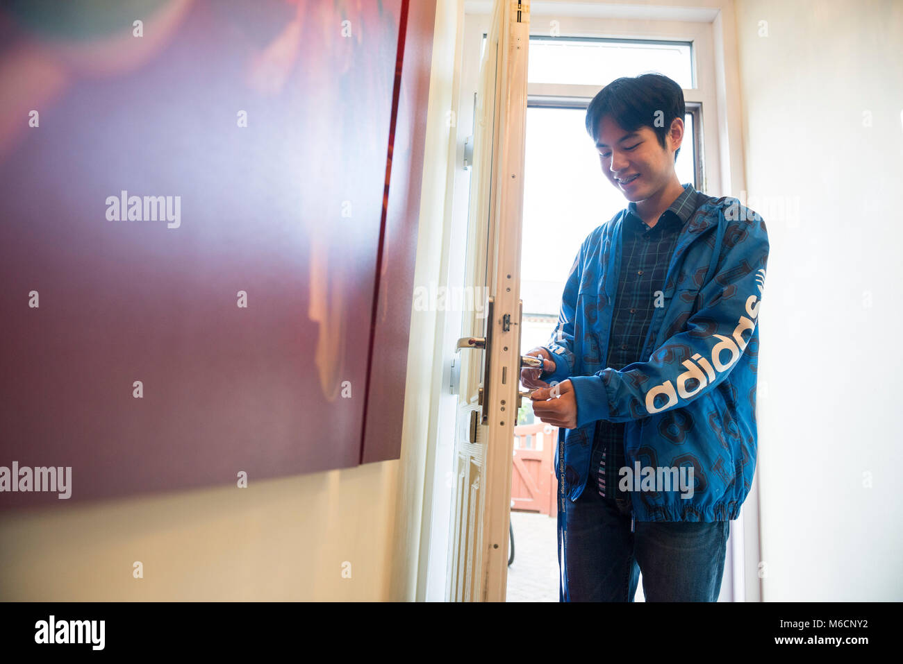 an international overseas student lets himself into his student let ...