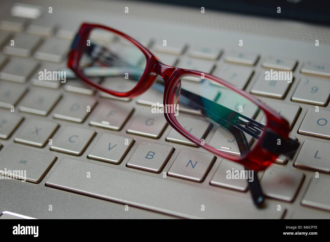 Tired eyeglasses on a bronze-colored laptop keyboard Stock Photo - Alamy