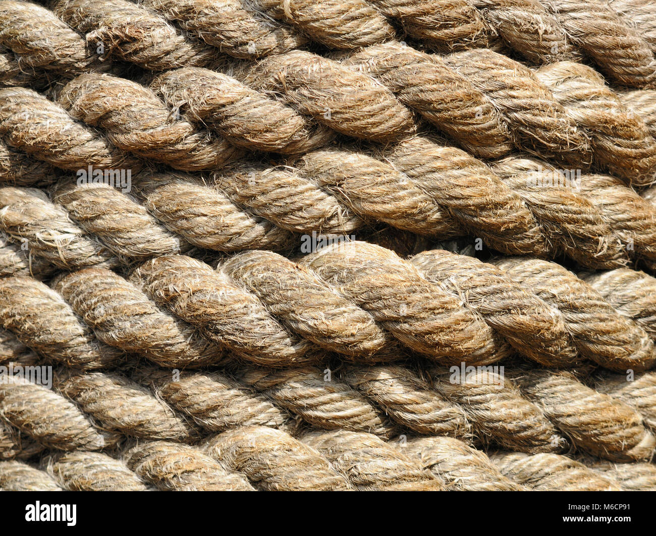 Stacked spool of rope in a horizontal pattern illuminated by sunlight ...
