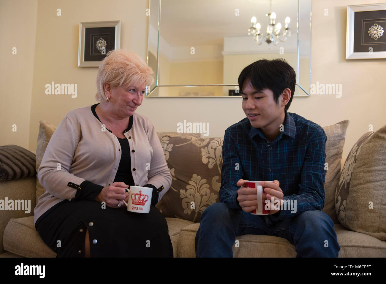 a young asian international student relaxes with his english host at ...