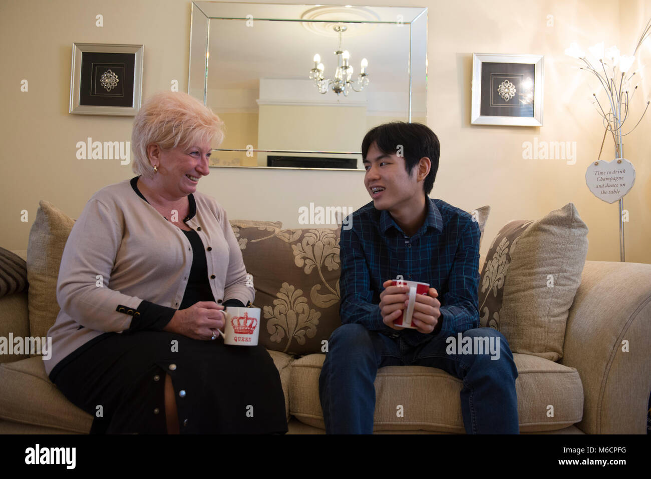 a young asian international student relaxes with his english host at ...