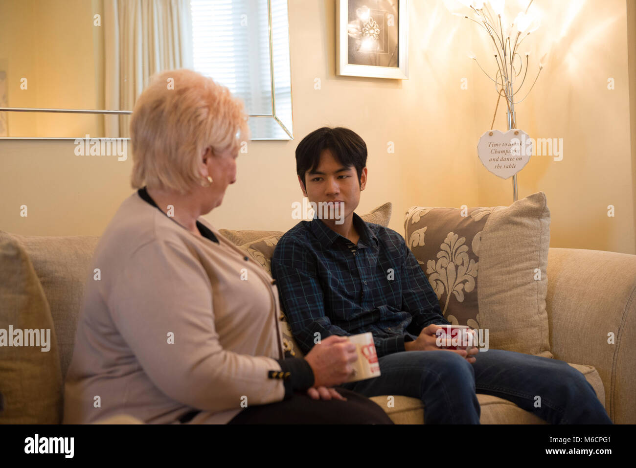 a young asian international student relaxes with his english host at ...