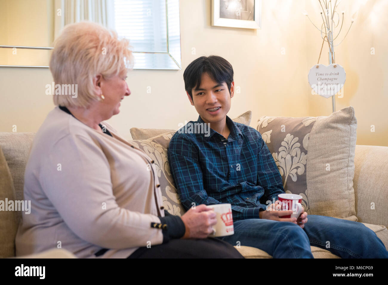 a young asian international student relaxes with his english host at ...