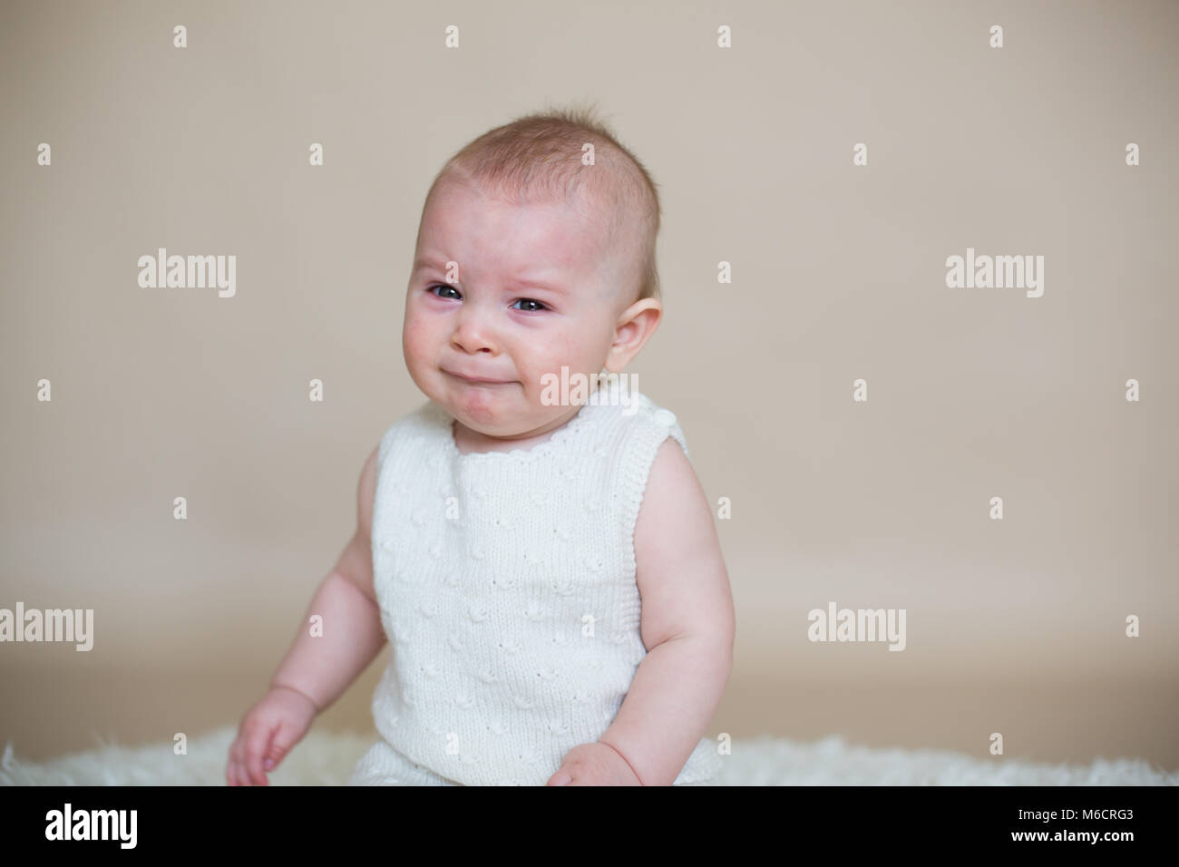 Close portrait of cute little baby boy, isolated on beige background ...