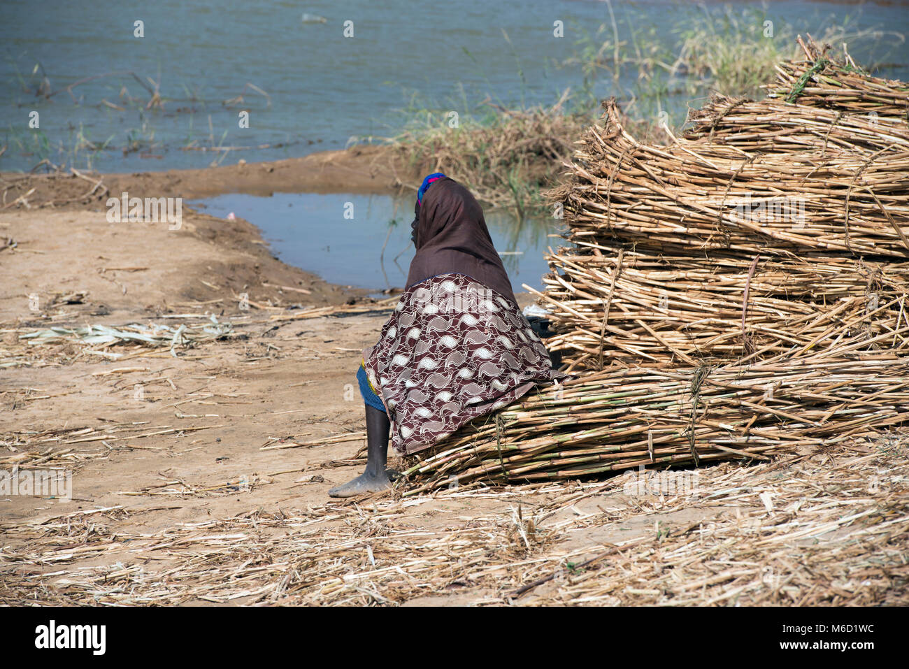 An ethnic, indigenous Bozo tribe woman waiting for a boat to take her ...