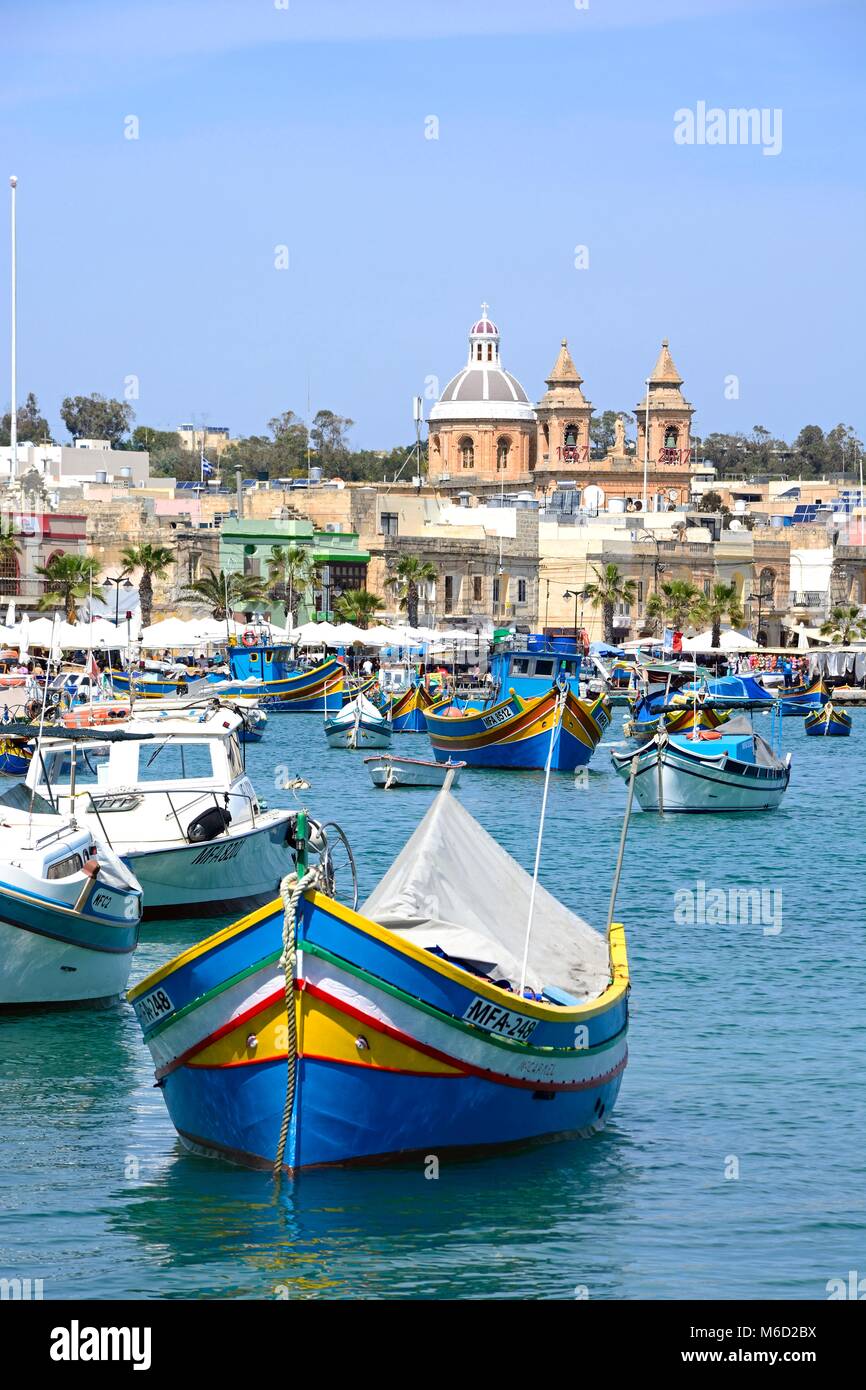 Traditional Maltese Dghajsa fishing boats in the harbour with the ...