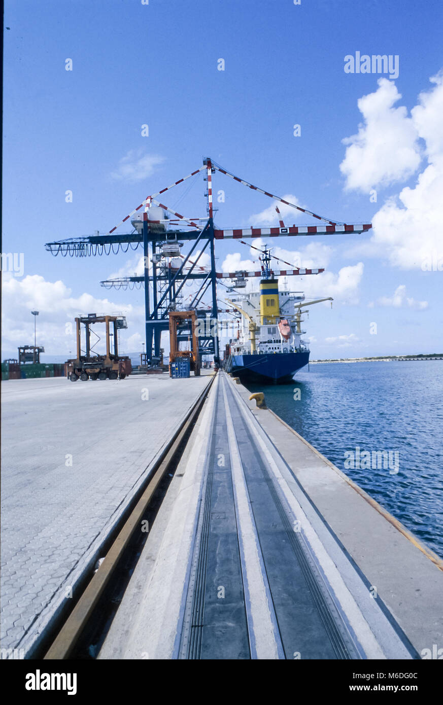 ship moored alongside the quay in a port with discharging operations ...