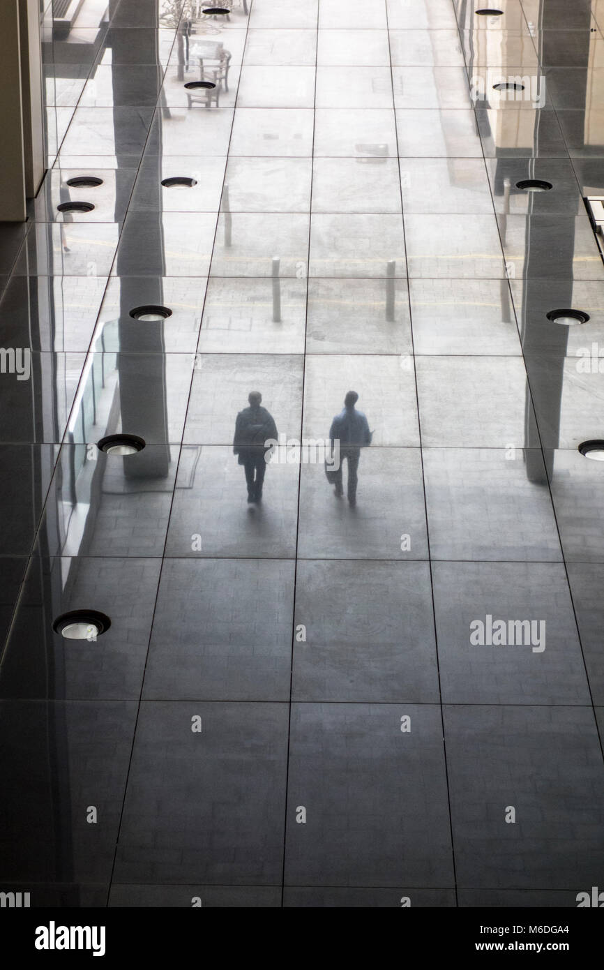 Reflection of two people walking in a city environment Stock Photo - Alamy