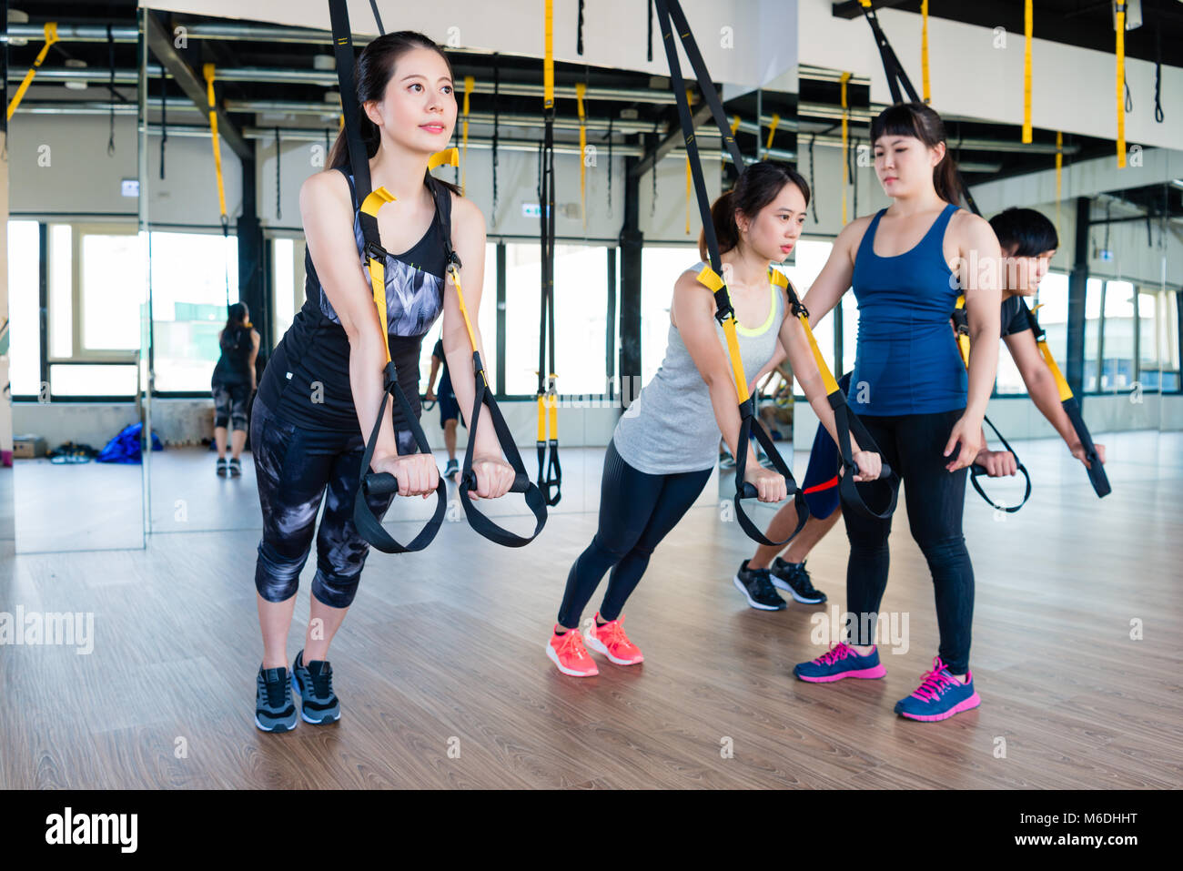 professional Asian fitness instructor teaching using the total body ...