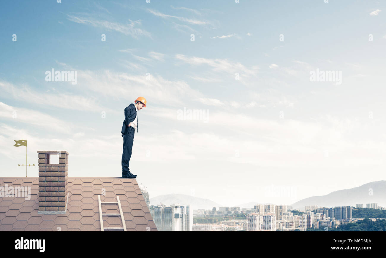 Businessman looking down from roof and modern cityscape at backg Stock ...