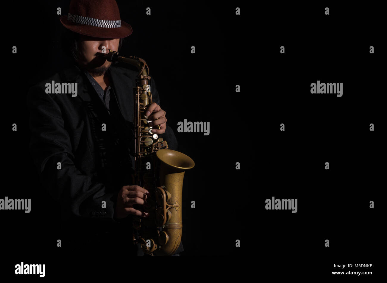 A saxophone player in a dark background Stock Photo - Alamy