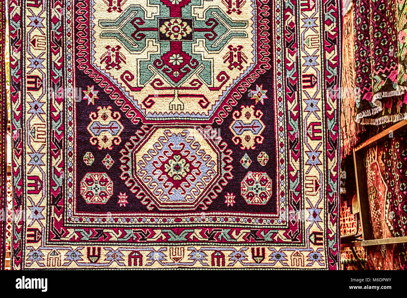 Woolen carpet with geometric ethnic patterns with red stylized curls on ...