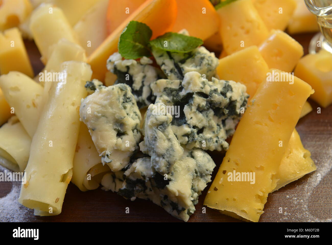 Assorted sliced cheese with mildew, blue, brie, swiss , cheddar ...