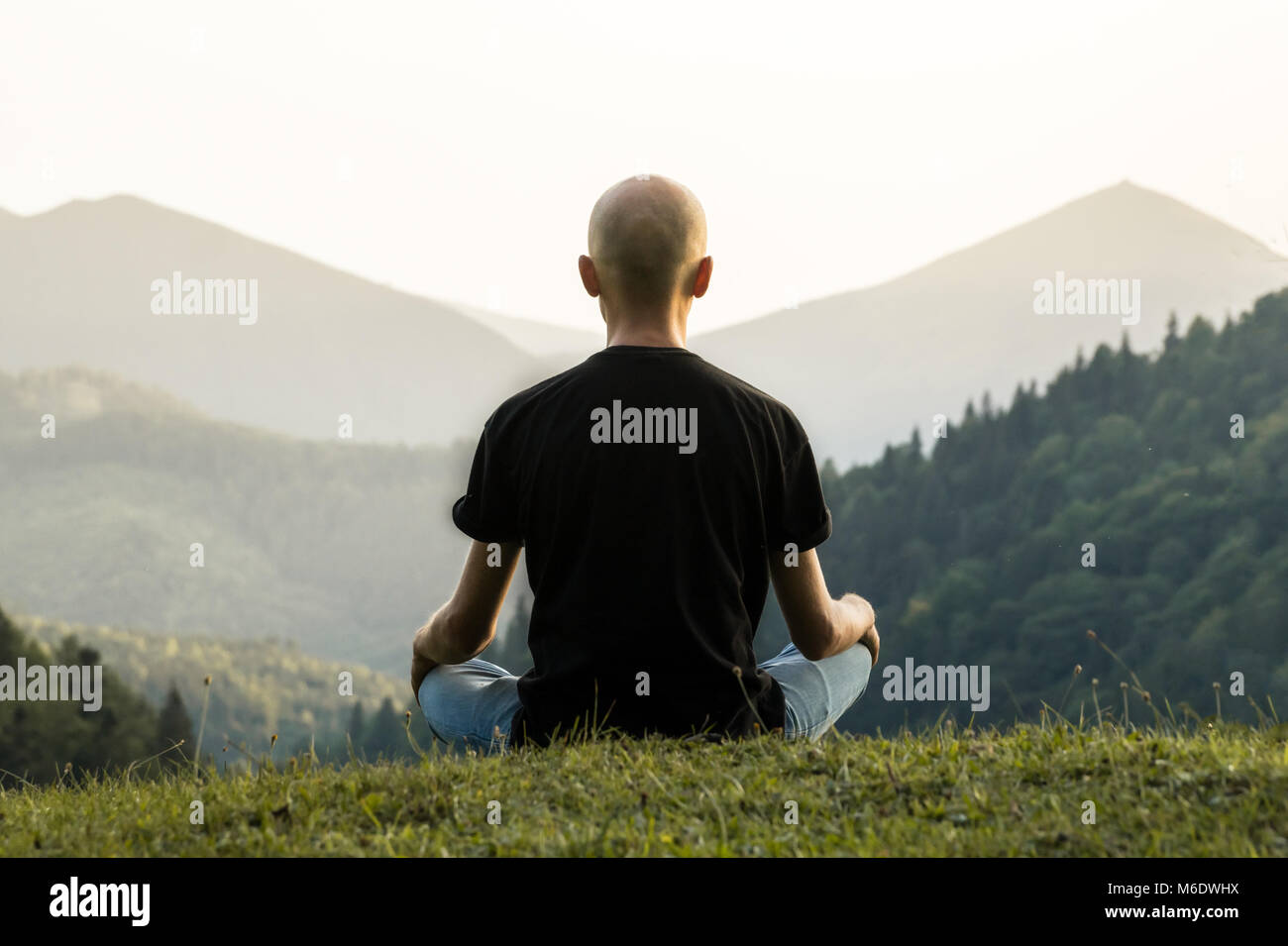 One man meditating sunset hi-res stock photography and images - Alamy