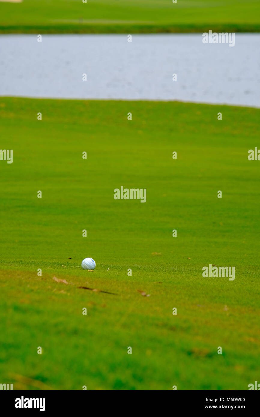 White Golf ball on Green Field of Golf Course, Lake in background Stock ...