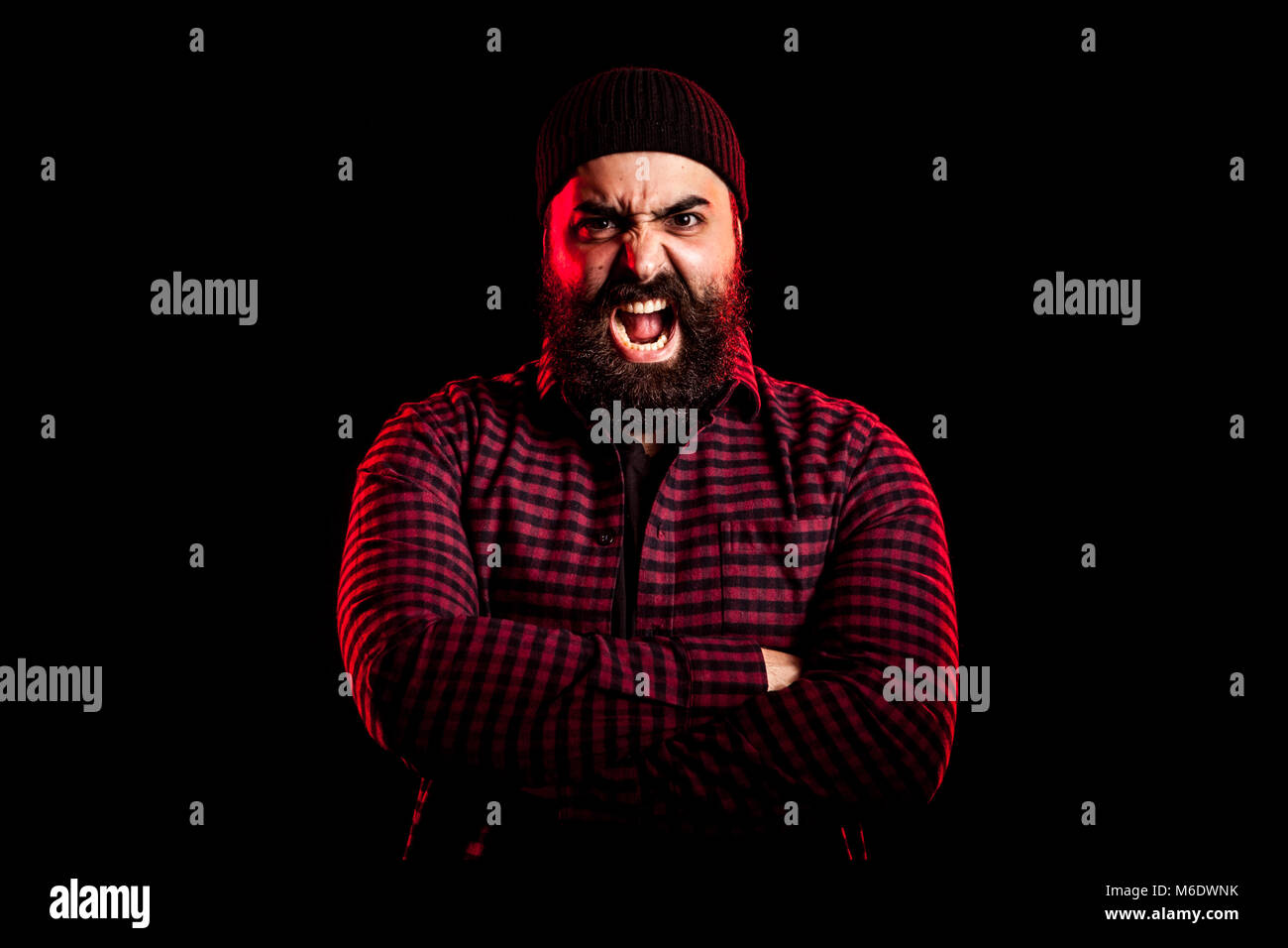 Bearded man screaming in anger on black background Stock Photo - Alamy