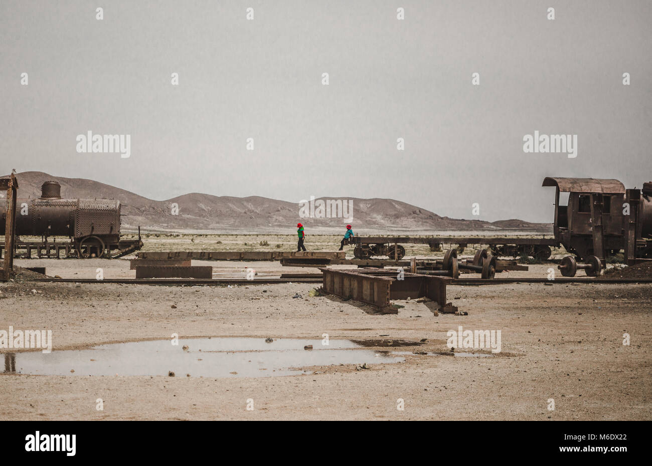Two young children play on their playground of rusty ruins of an old ...