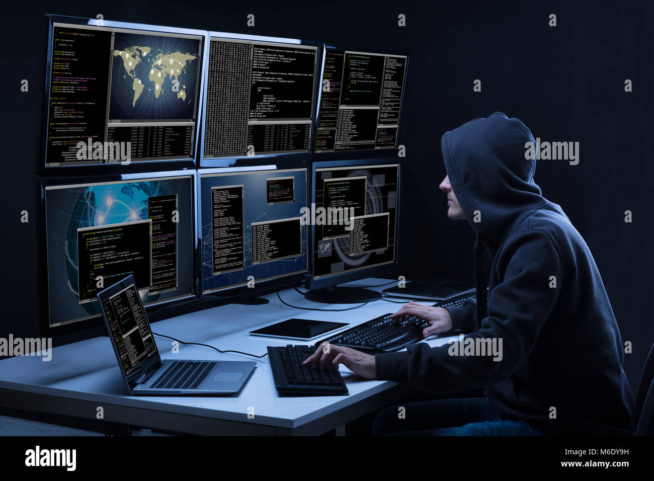 Rear View Of A Hacker Using Multiple Computers For Stealing Data In Office Stock Photo - Alamy