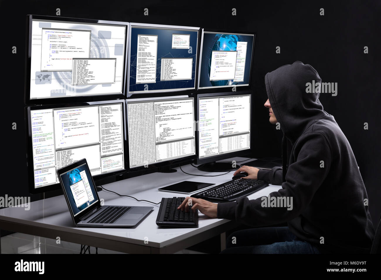Rear View Of A Hacker Using Multiple Computers For Stealing Data In Office Stock Photo - Alamy