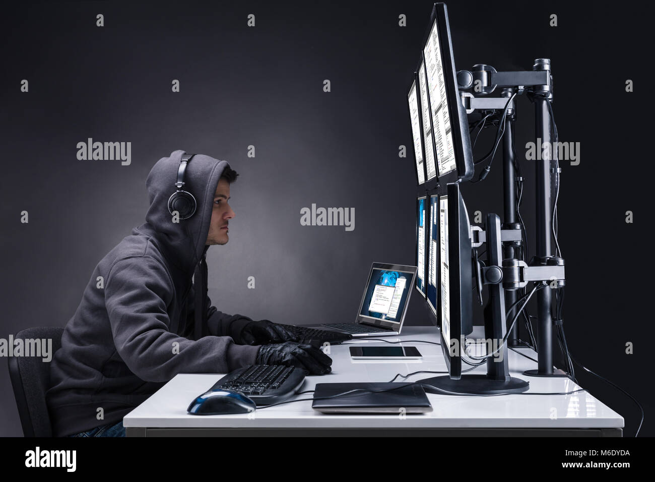 Rear View Of A Hacker Using Multiple Computers For Stealing Data In 2304